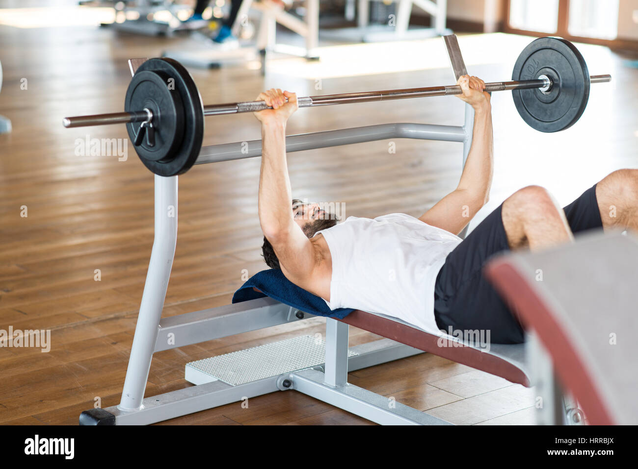 Man lifting a weight in a fitness club Stock Photo - Alamy