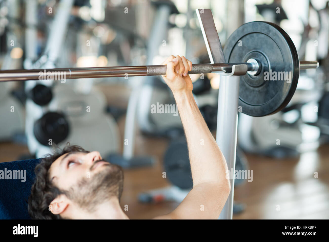 Man lifting a weight in a fitness club Stock Photo - Alamy