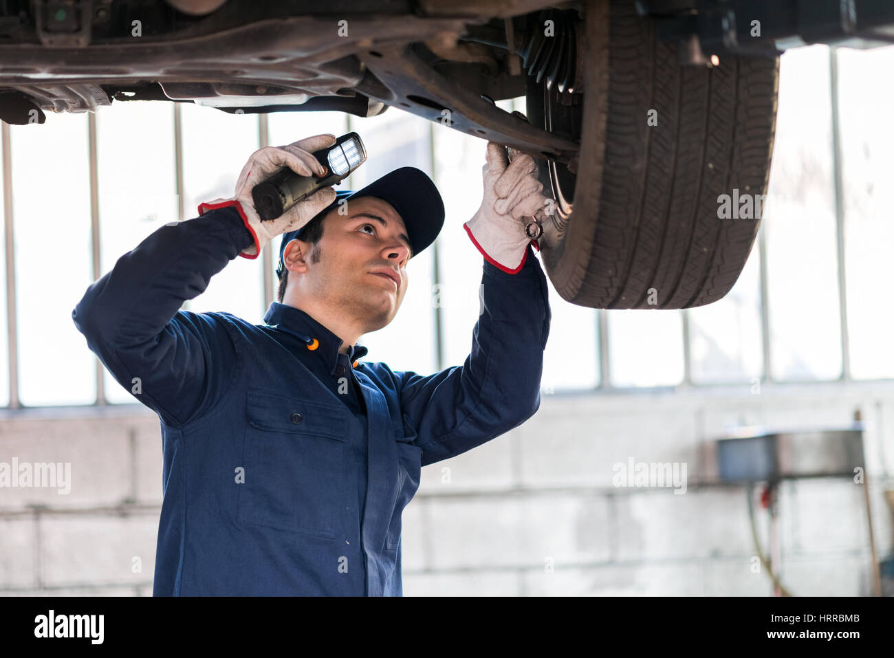 Mechanic inspecting a lifted car Stock Photo - Alamy
