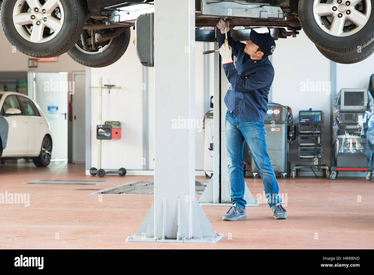 Mechanic fixing a lifted car Stock Photo - Alamy