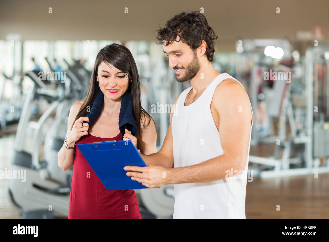 Personal trainer explaining an exercise to a woman Stock Photo - Alamy