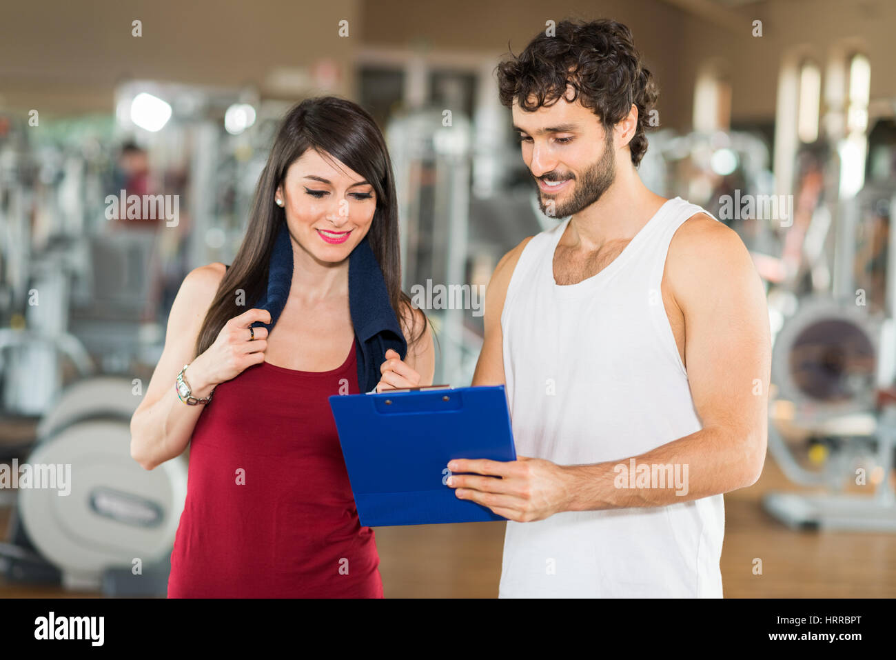 Personal trainer explaining an exercise to a woman Stock Photo - Alamy