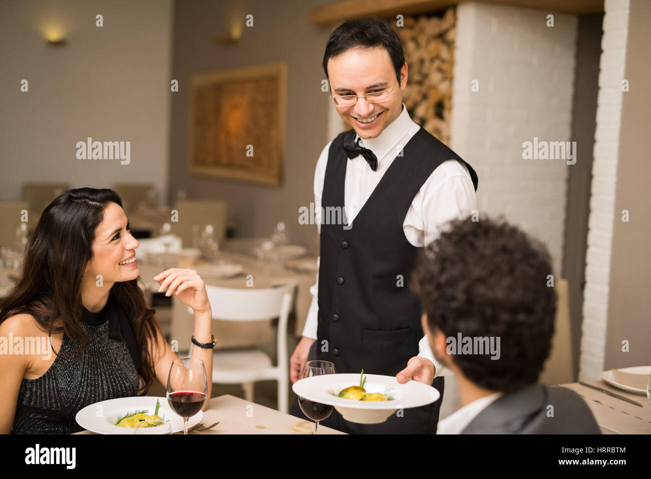Waiter serving two customers Stock Photo - Alamy