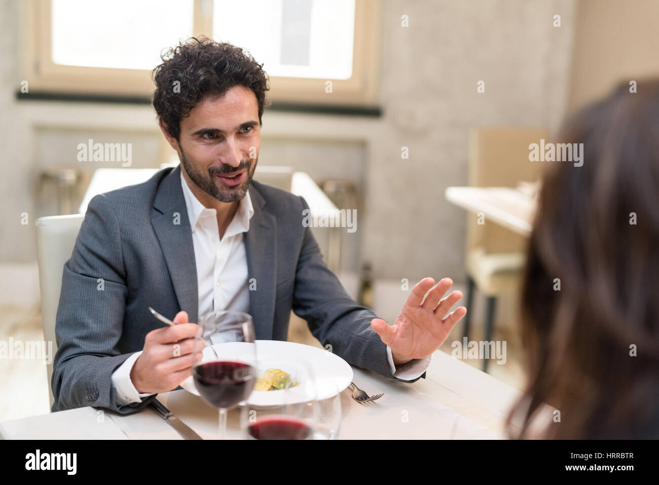 Man speaking while eating at the restaurant Stock Photo - Alamy