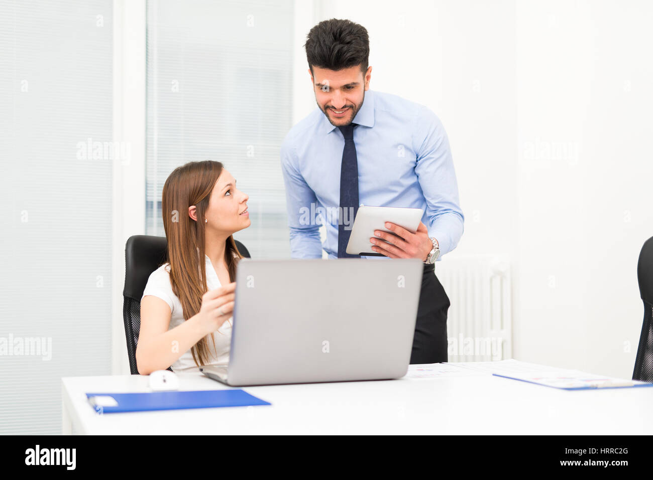 Team using a laptop computer in her office Stock Photo - Alamy