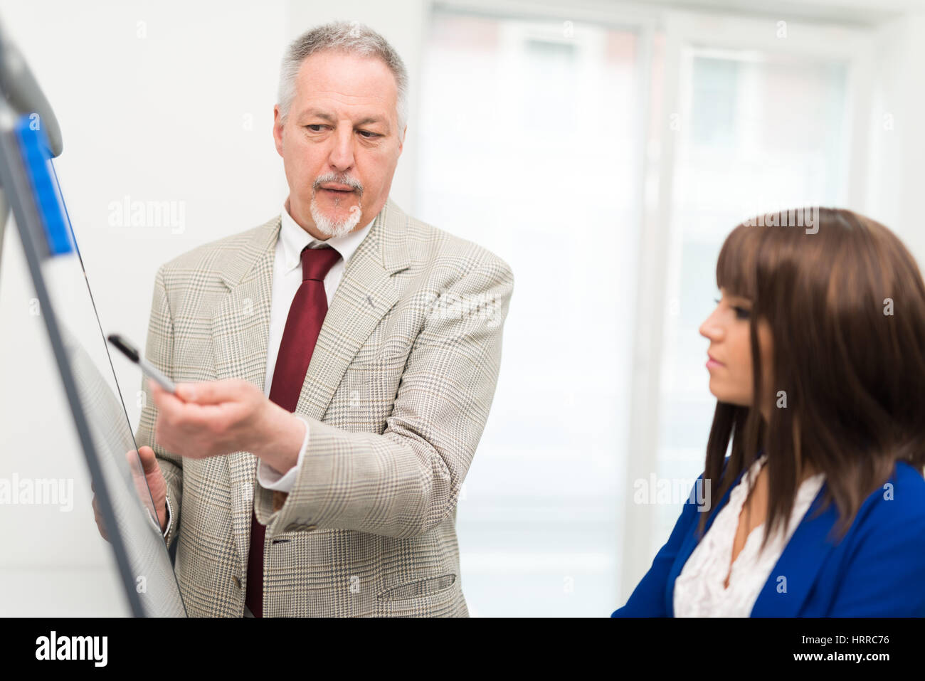 Business class, senior businessman explaining financial concepts to a ...