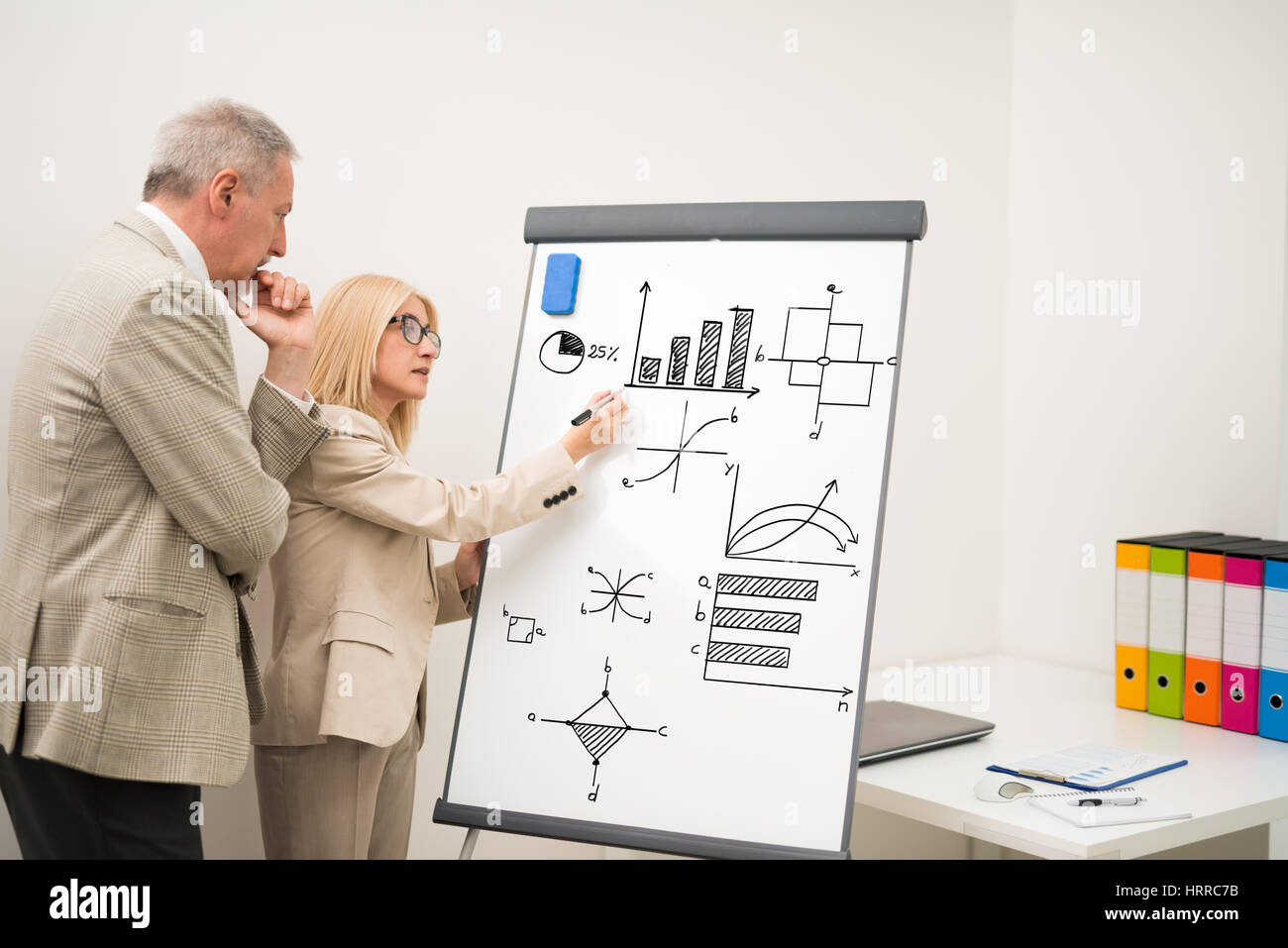Business people writing on a whiteboard in their office Stock Photo - Alamy