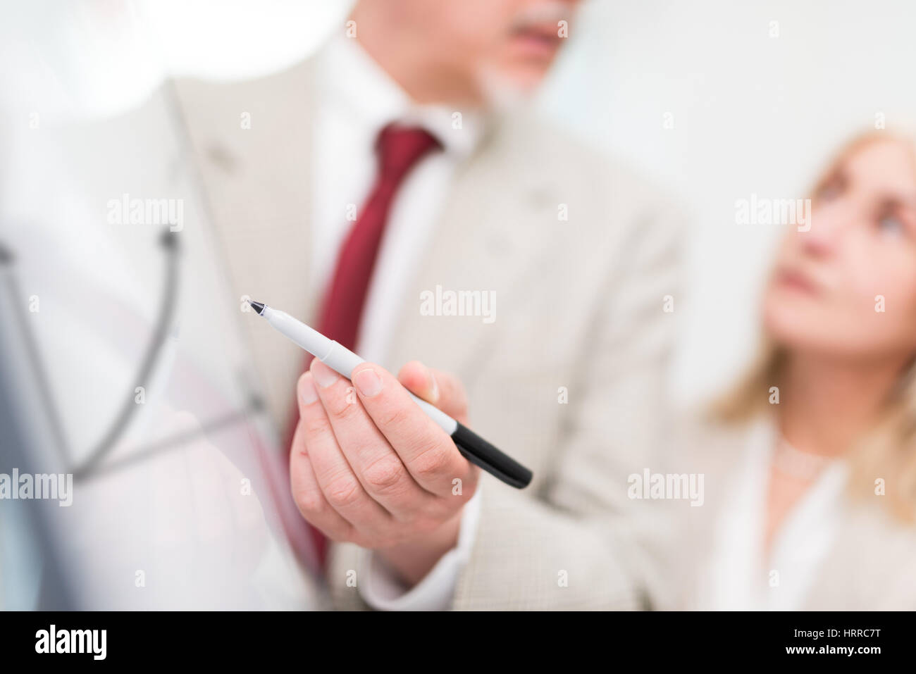 Business people writing on a whiteboard in their office Stock Photo - Alamy
