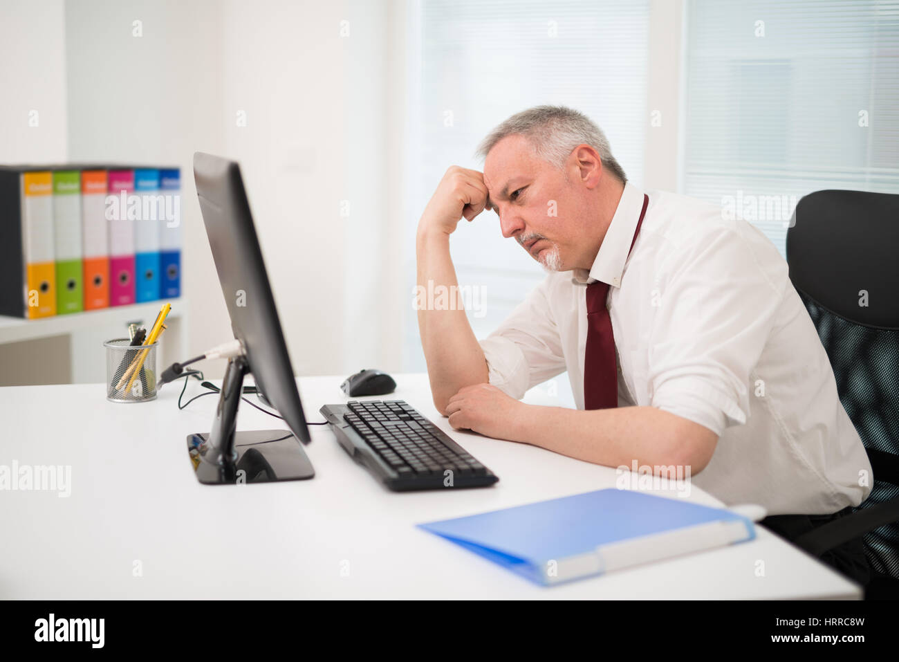 Sad businessman looking at his computer monitor Stock Photo - Alamy