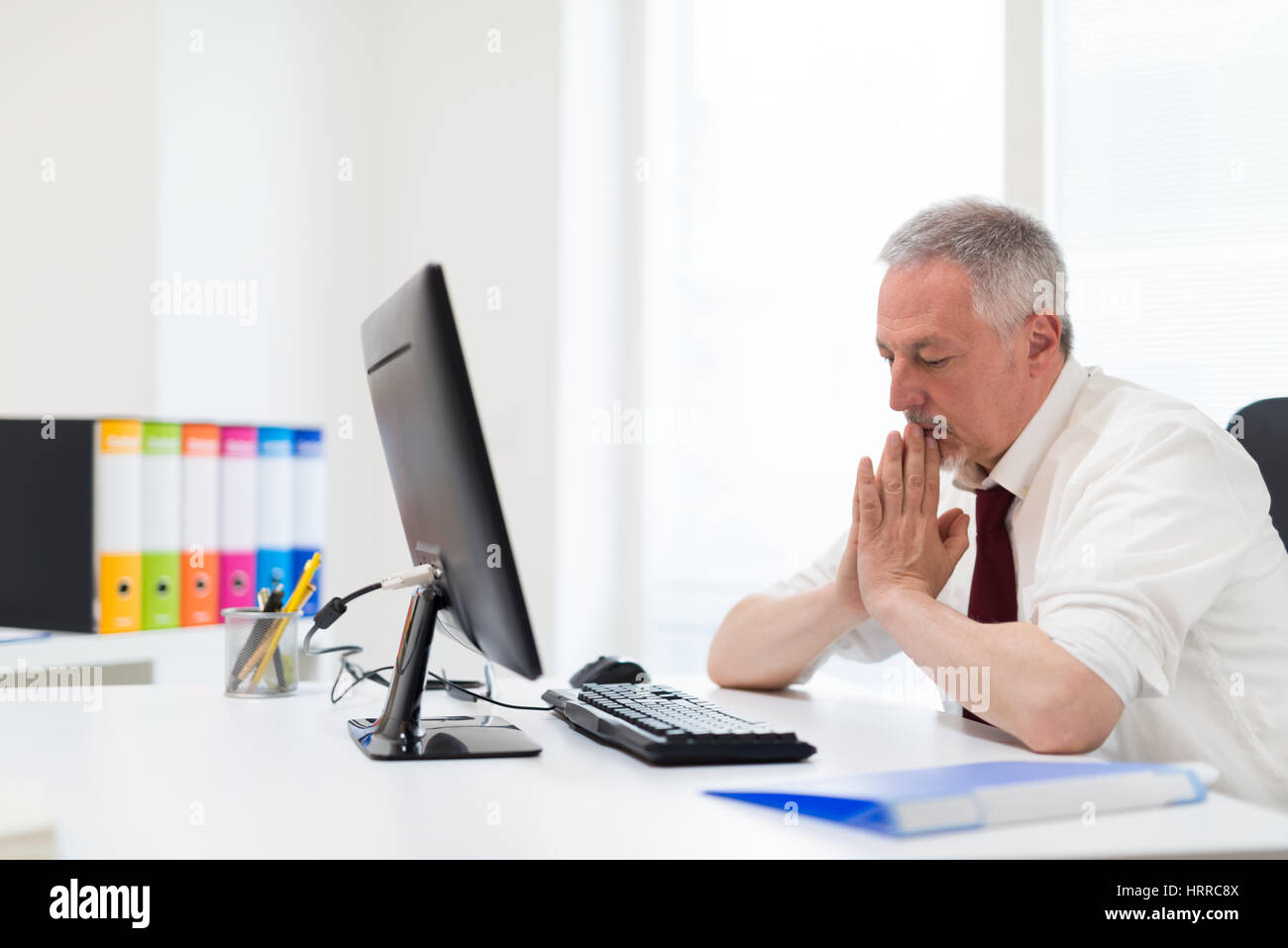 Man thinking about something in front of his computer Stock Photo - Alamy