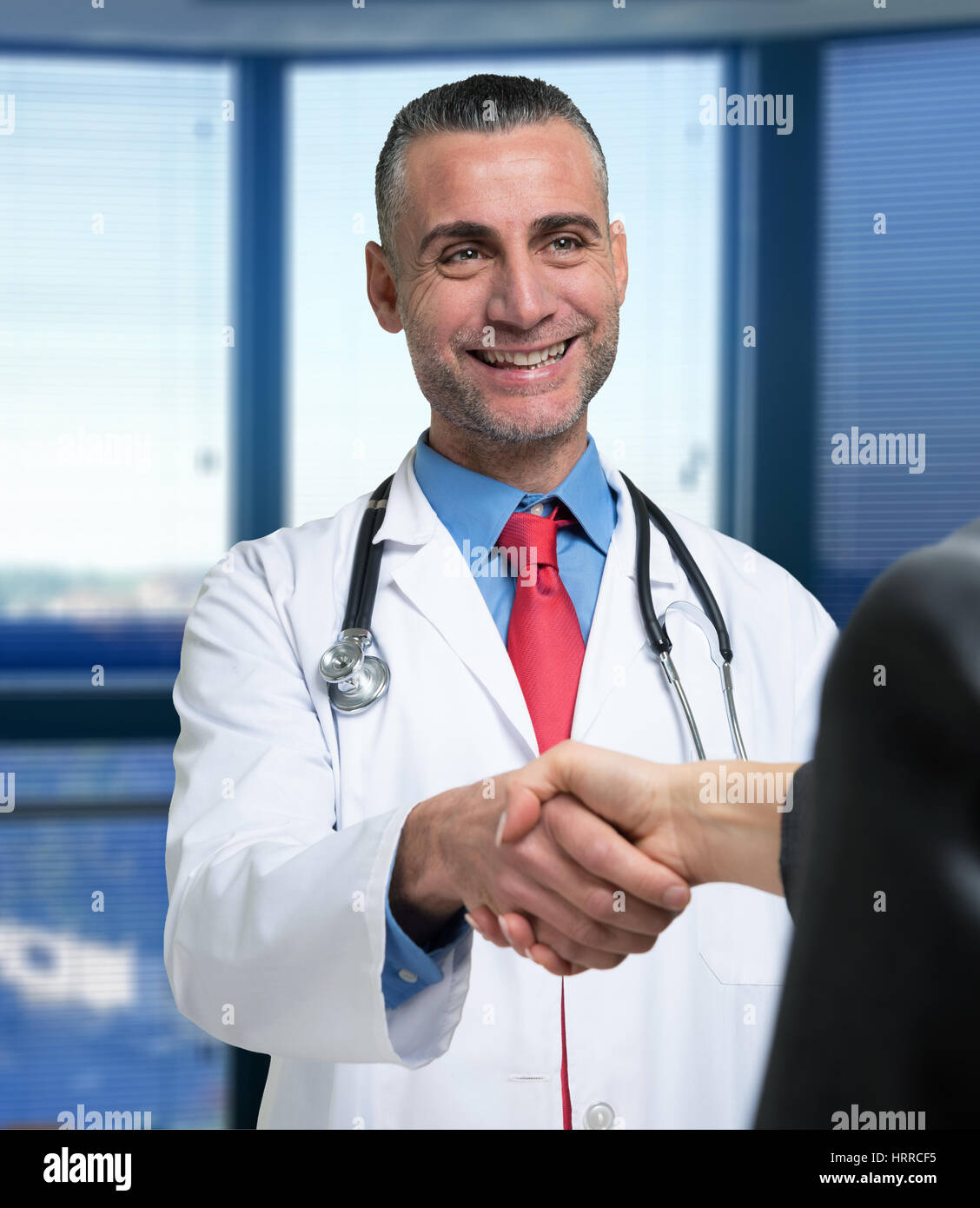 Smiling doctor giving an handshake to a patient Stock Photo - Alamy