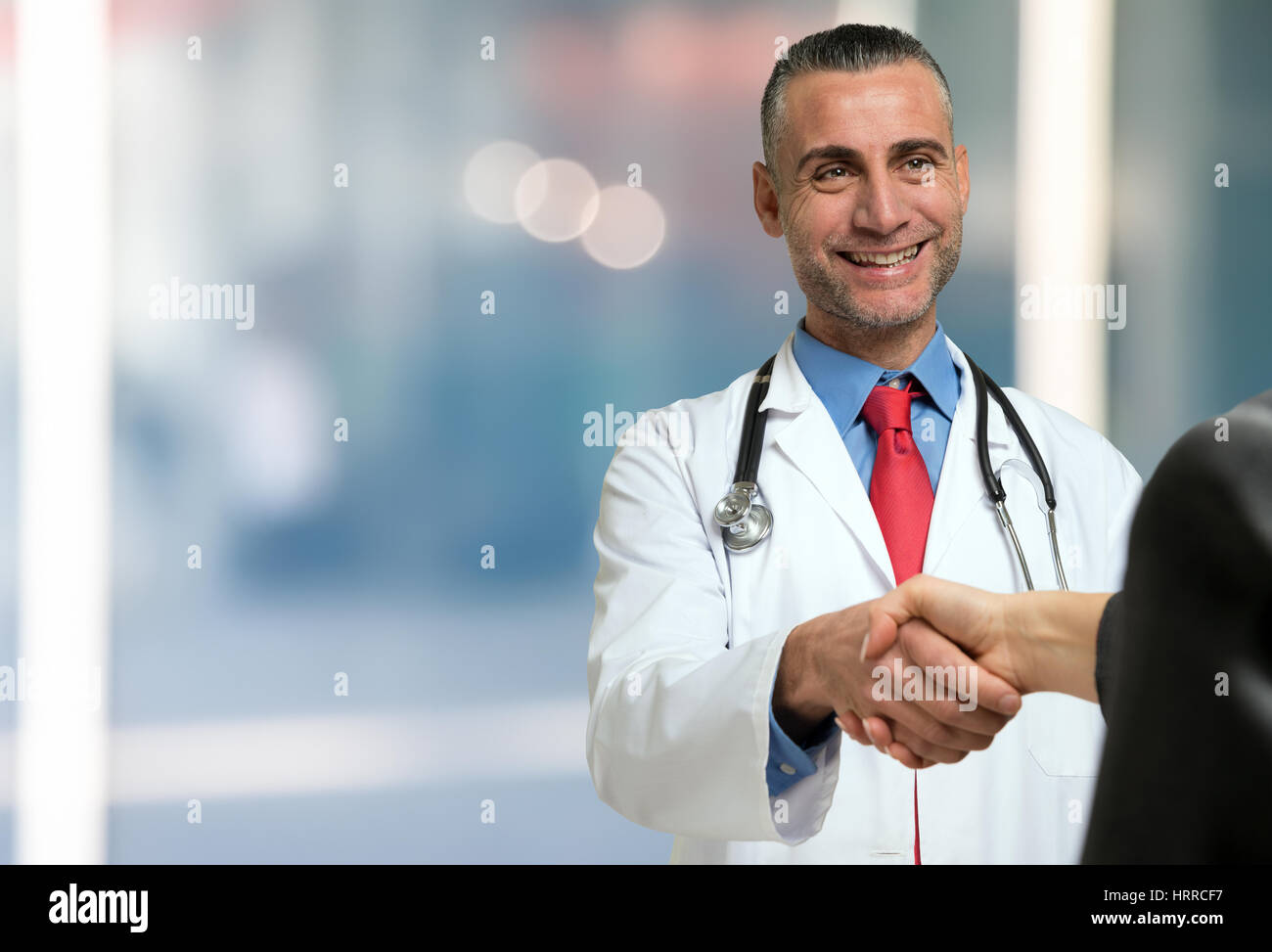 Smiling doctor giving an handshake to a patient Stock Photo - Alamy