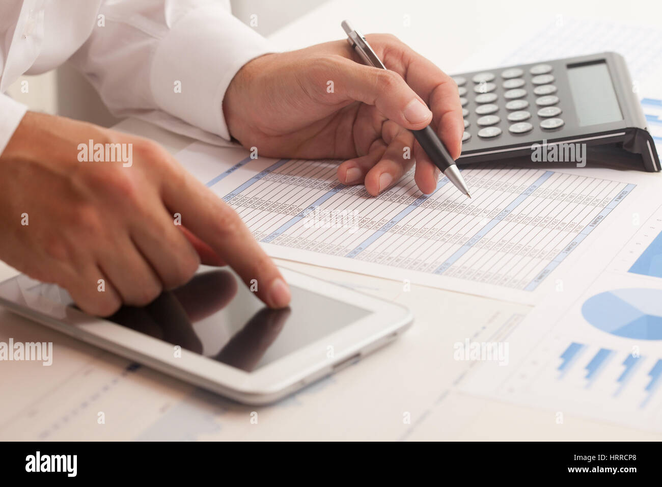 Man working on a tablet computer and financial charts Stock Photo - Alamy