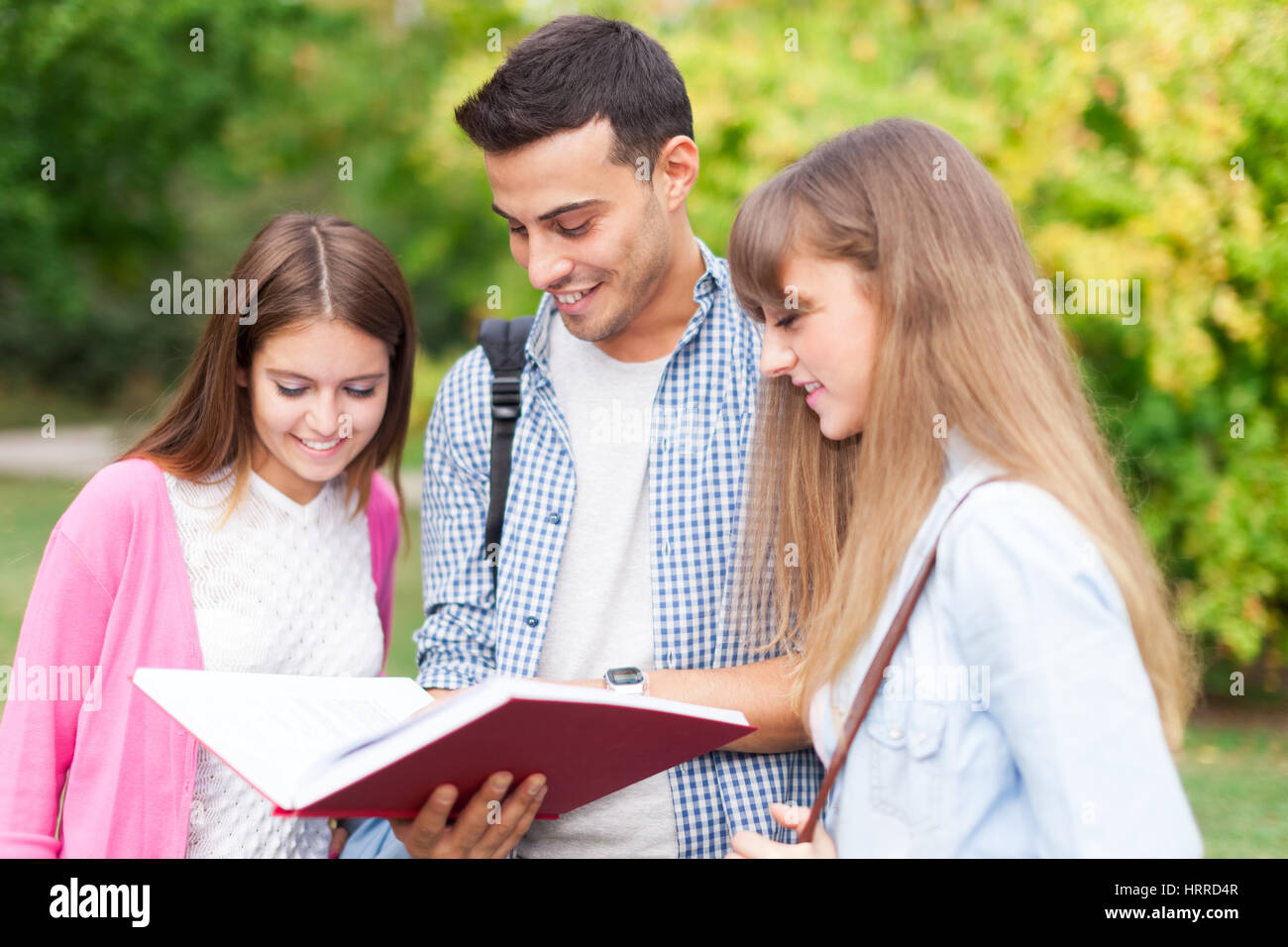 Three girls reading book hi-res stock photography and images - Alamy