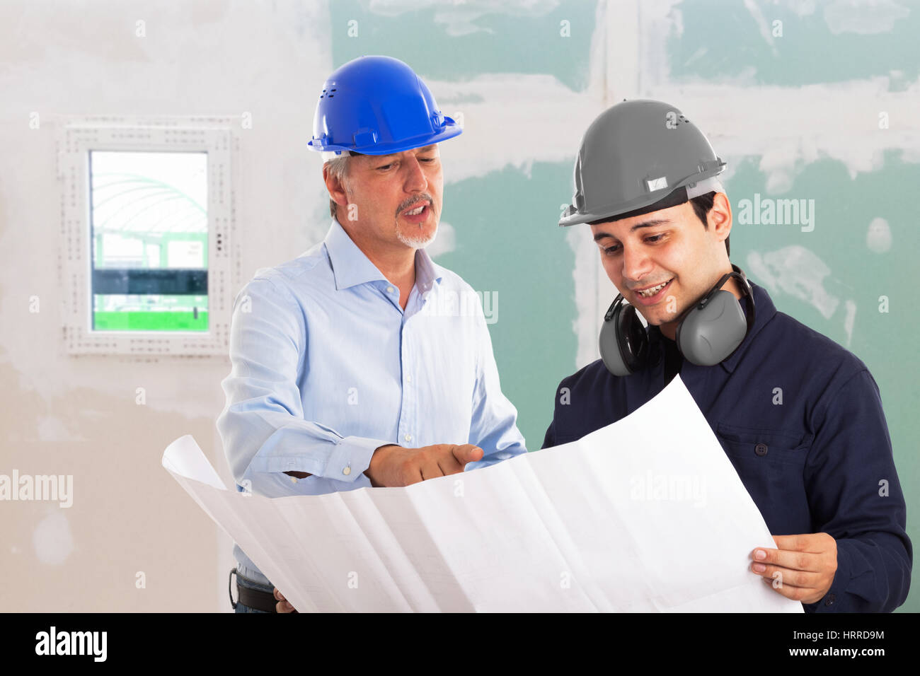 Architect explaining a drawing to the foreman Stock Photo - Alamy