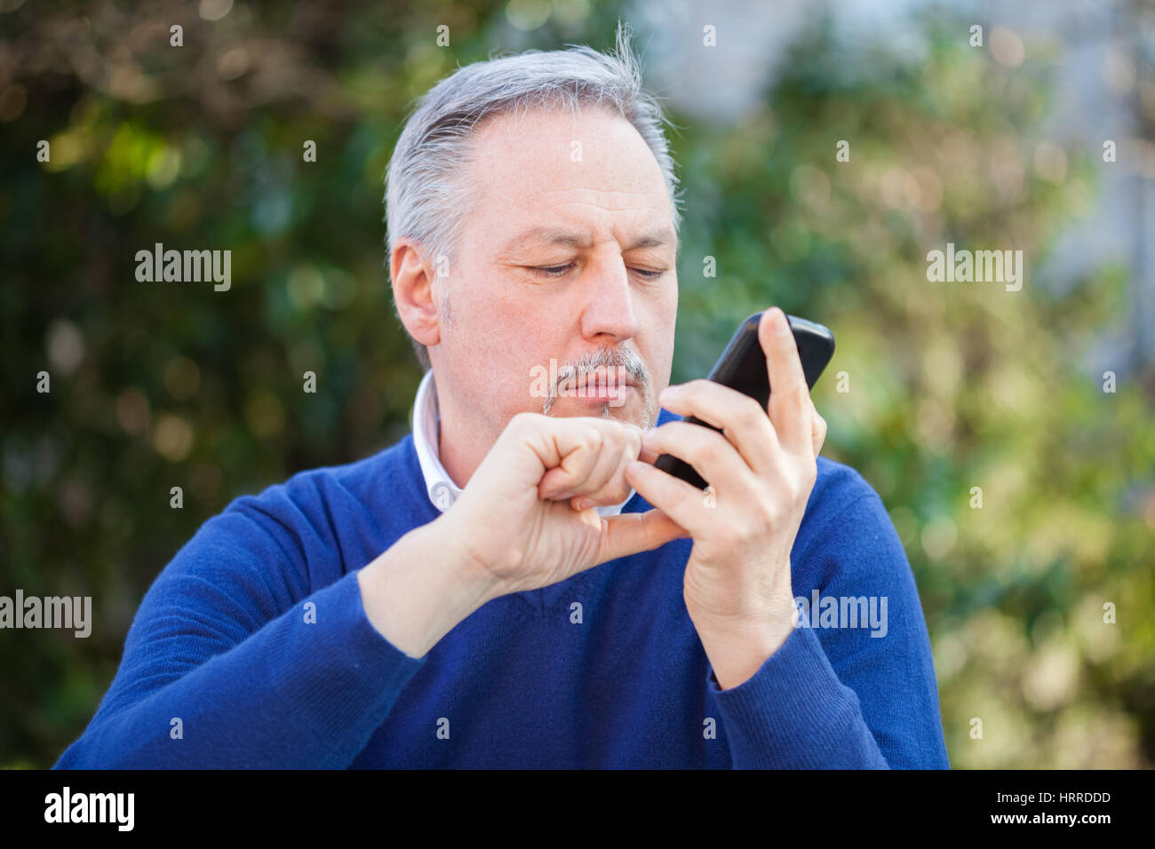 Old man using touchscreen smartphone hi-res stock photography and ...
