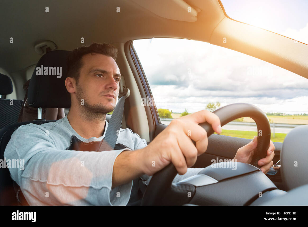 Detail of a man driving his car. Bright light effect Stock Photo - Alamy
