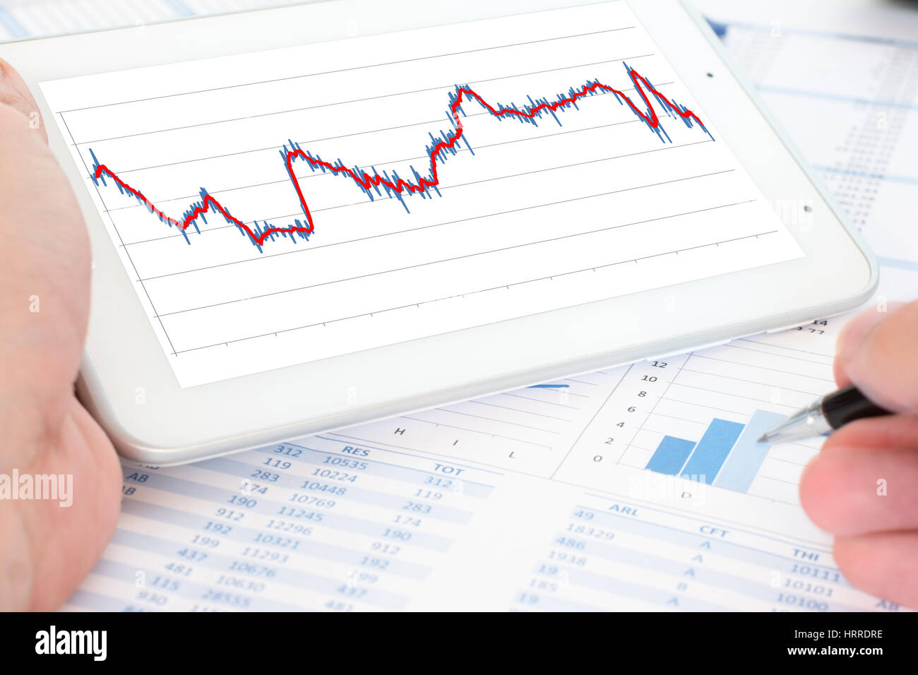 Man checking data while writing on a diagram Stock Photo - Alamy