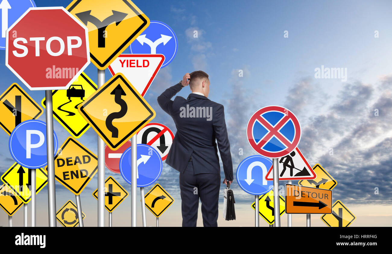 Businessman is confused due to a lot of road signs, tries choosing the ...