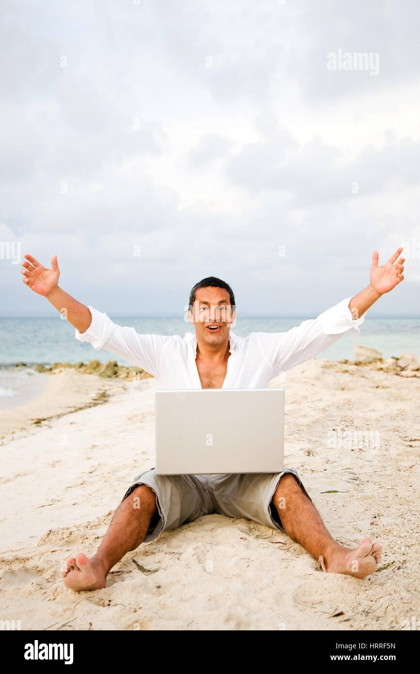 successful business man on holiday using his laptop Stock Photo - Alamy