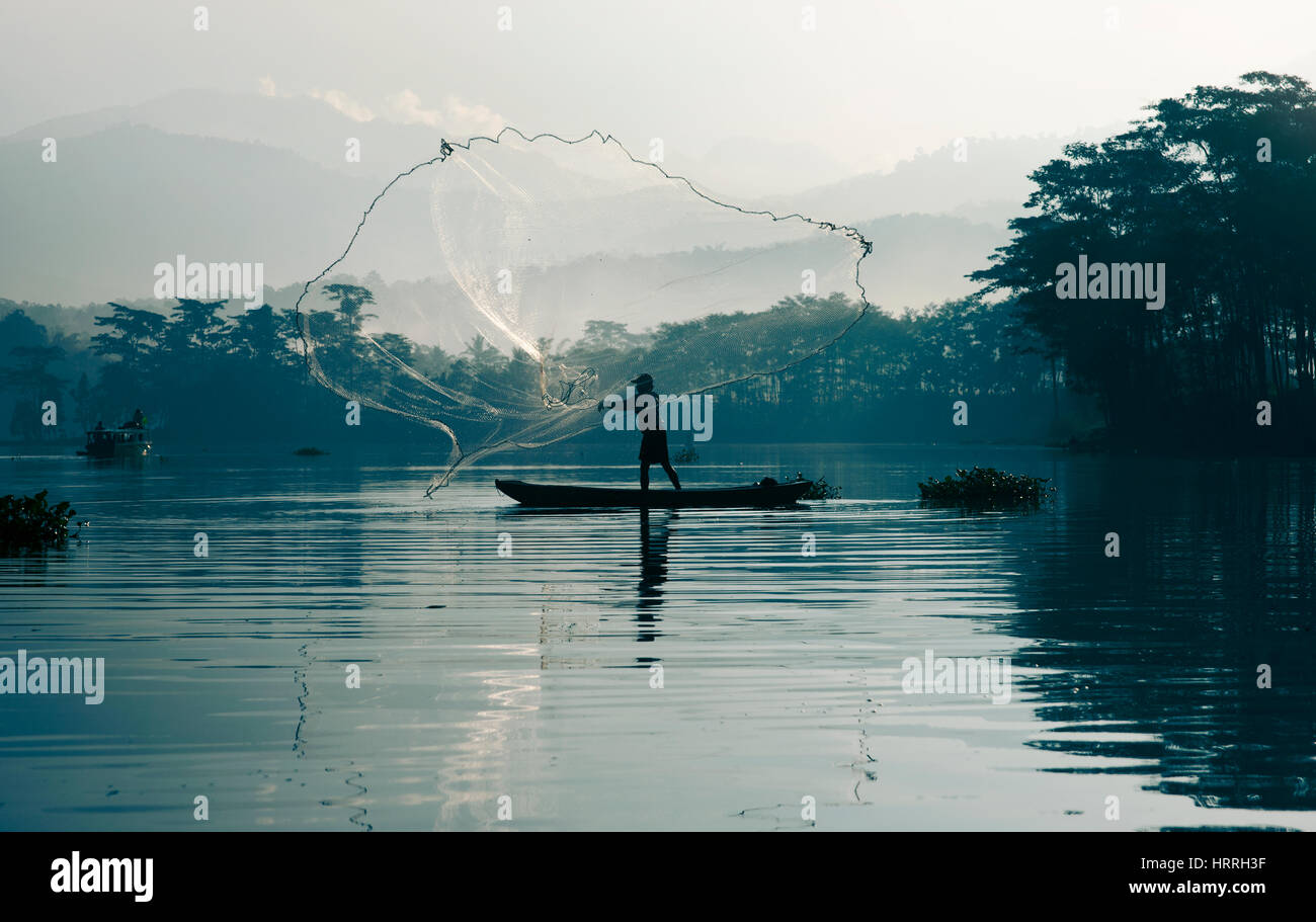 Man throwing fishing net into water hi-res stock photography and images ...