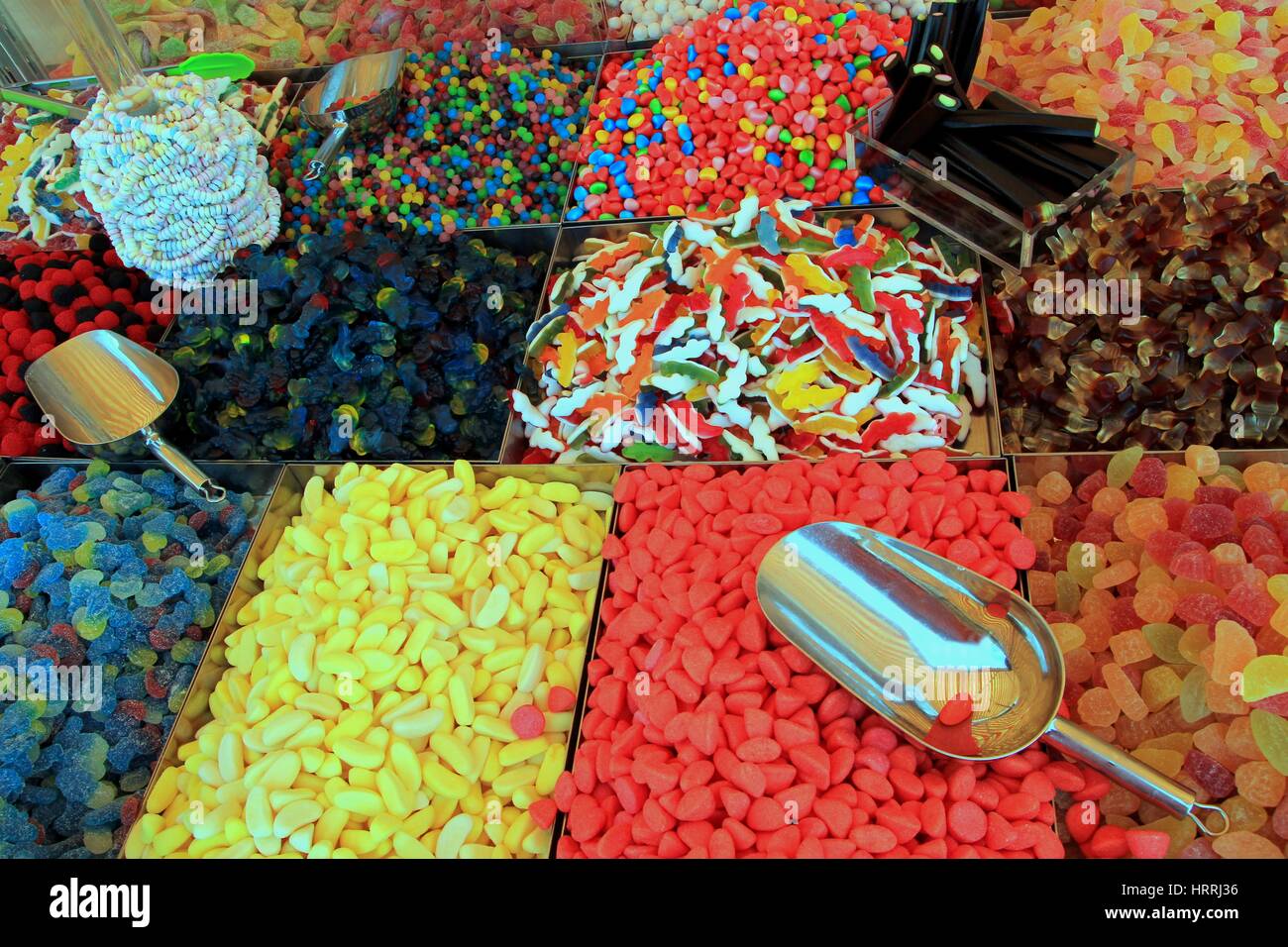Trays of colorful candy sweets, red, blue, yellow and multi-coloured ...