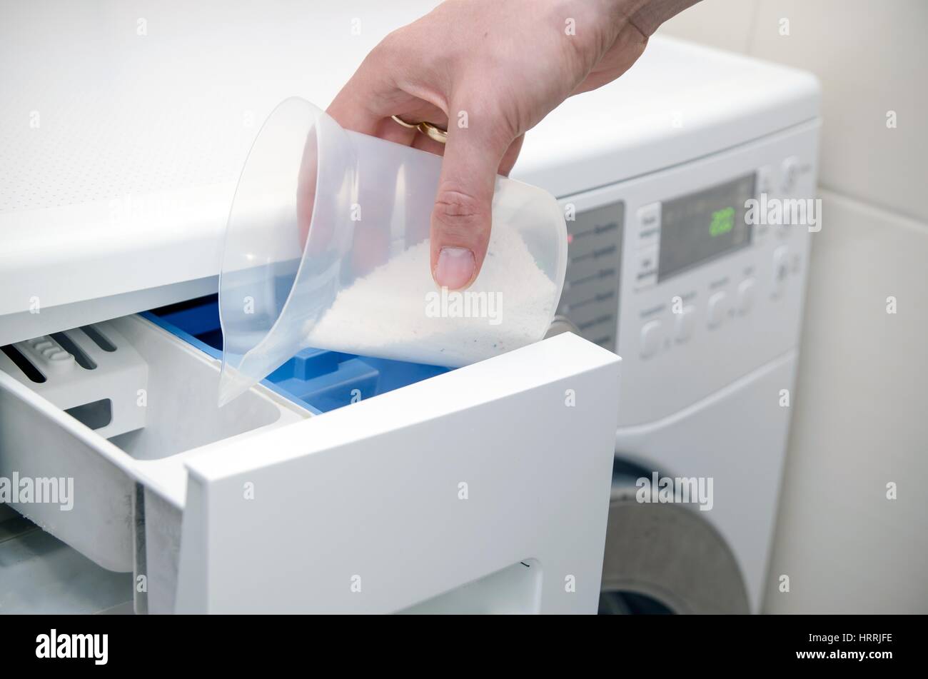 Woman hand pouring washing powder into the washing machine Stock Photo ...
