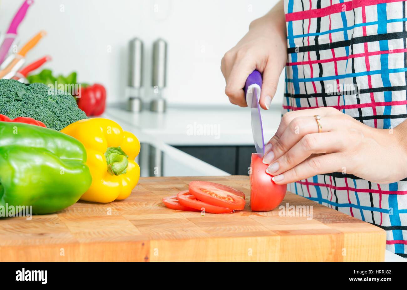 Woman chef cutting peppers. Food preparation in modern kitchen Stock ...