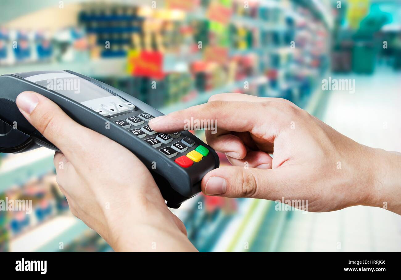 Hand with credit card swipe through terminal for sale in supermarket ...