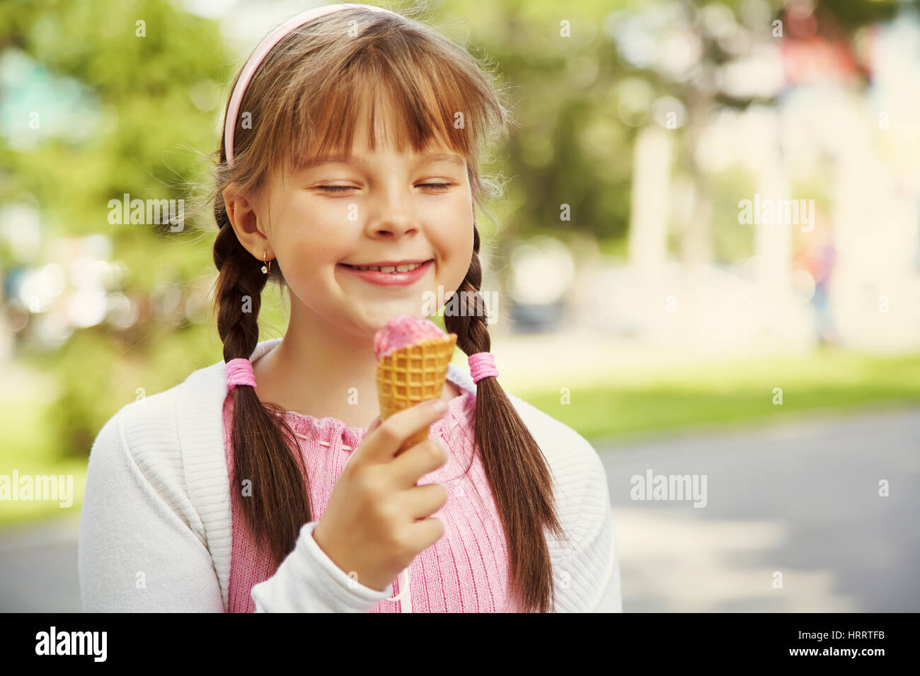 Portrait of a cute girl with ice cream on a walk in the park. child ...