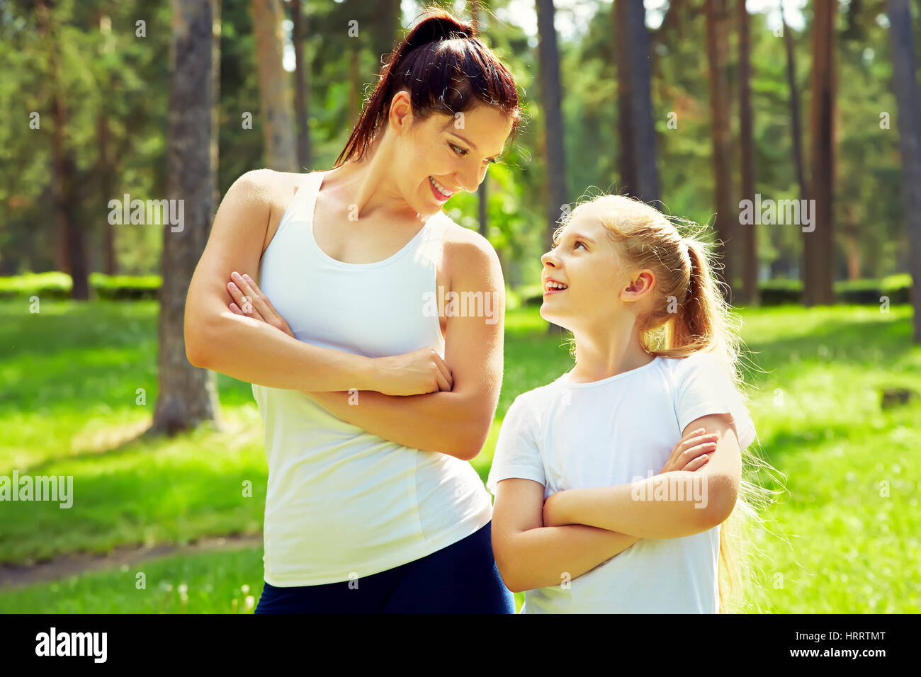 sporty mother and daughter. woman and child training in the park ...