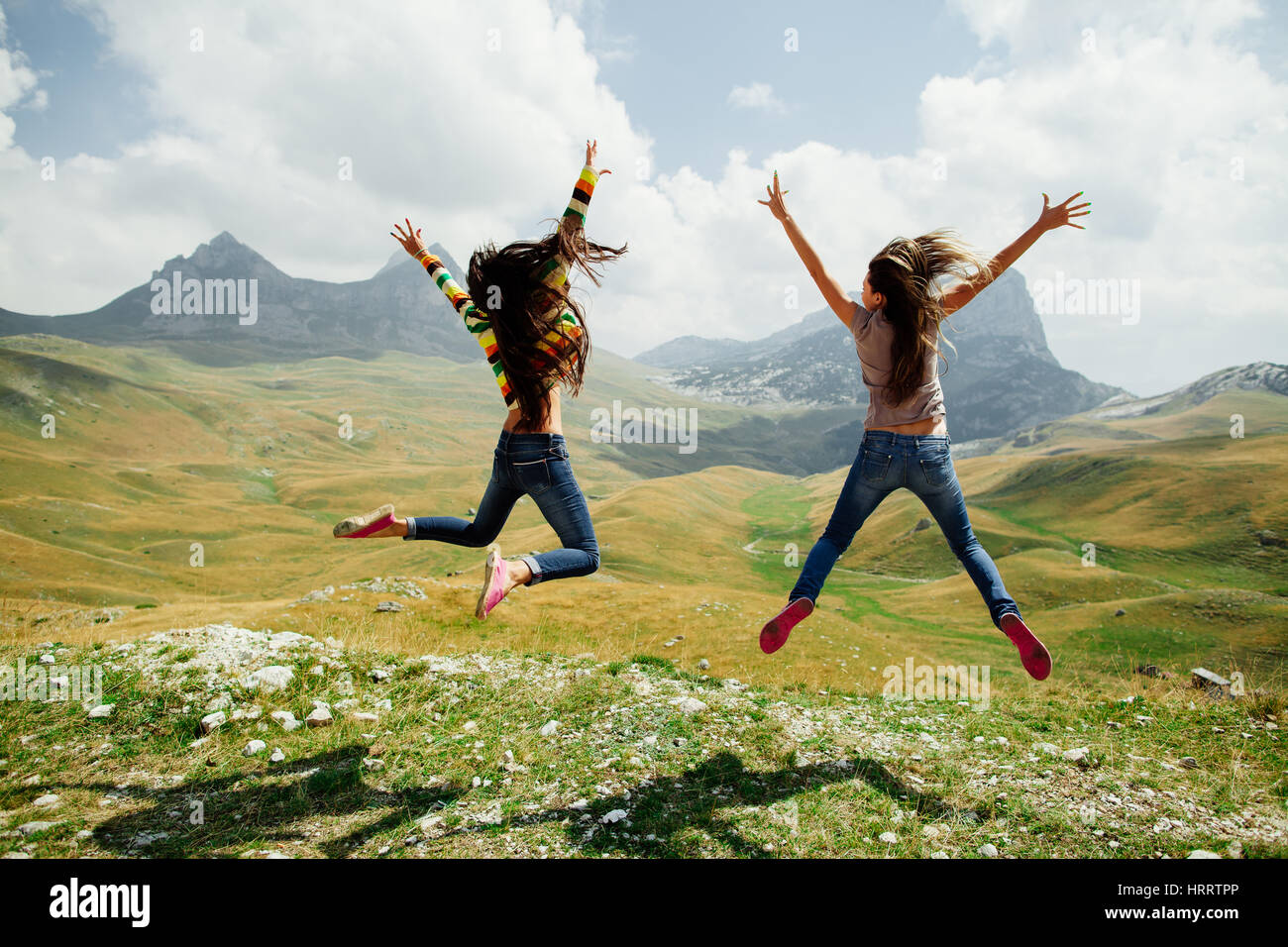 Back view two young women jumping in hi-res stock photography and ...