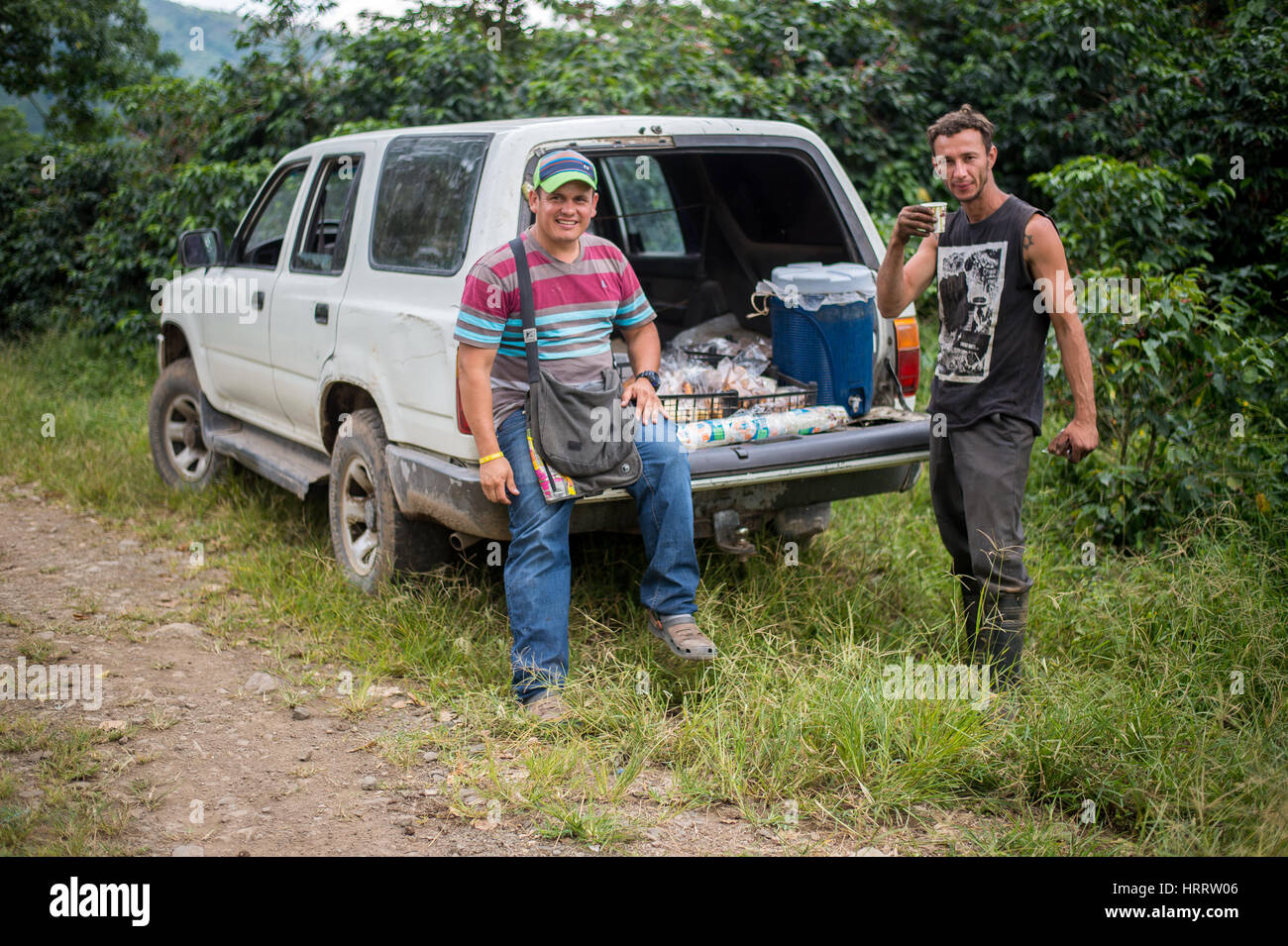 Coffee workers posing for a photograph and drinking coffee on a coffee ...
