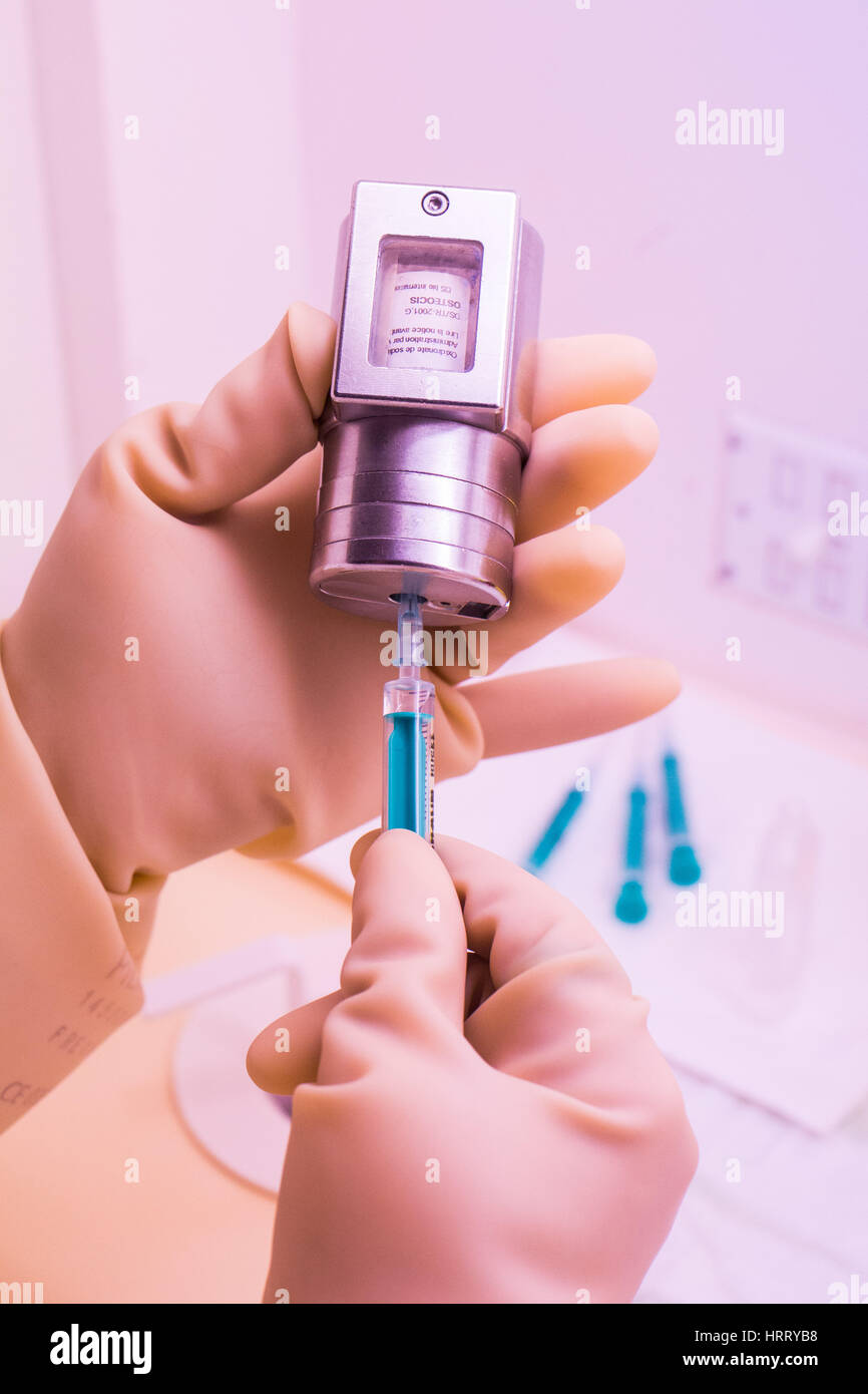 Syringe equiped with a lead shield to protect the technician from the ...