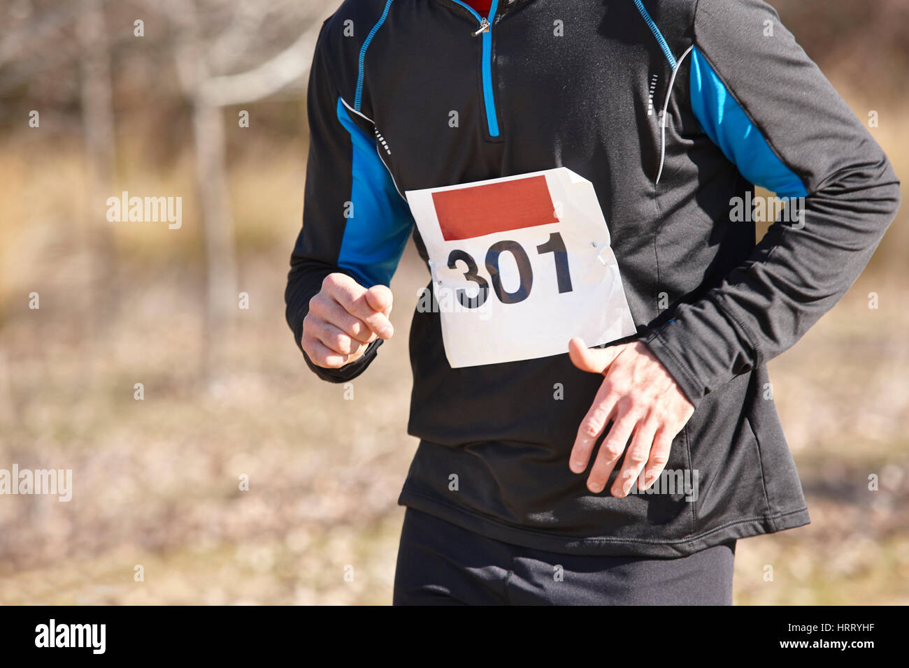 Male athletic runner on a cross country race. Outdoor circuit ...