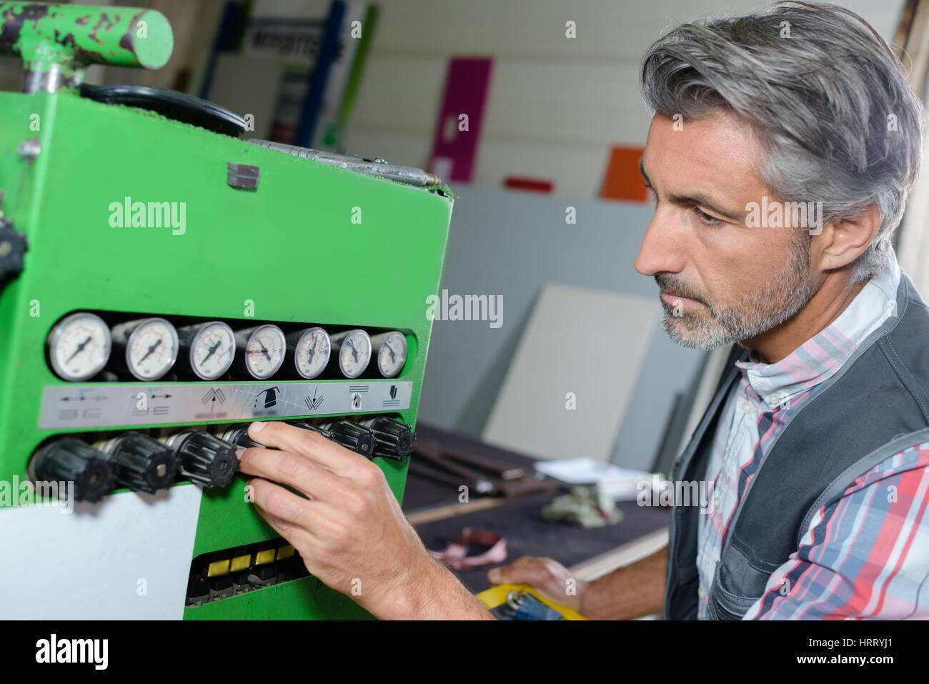 Man adjusting dial on control panel Stock Photo - Alamy