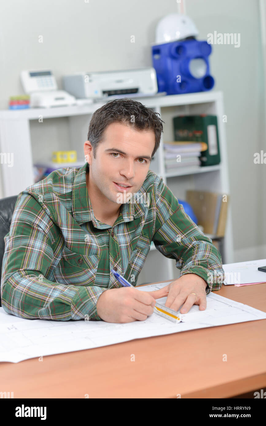 Man sat at desk working on scale drawings Stock Photo - Alamy