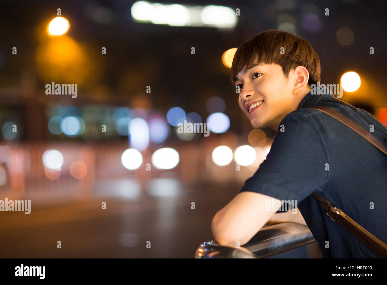 Young man waiting at the bus stop Stock Photo - Alamy