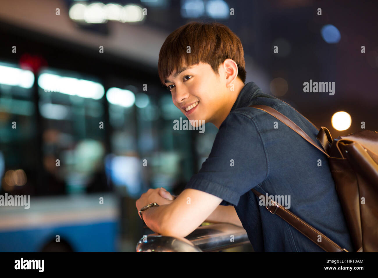Young man waiting at the bus stop Stock Photo - Alamy