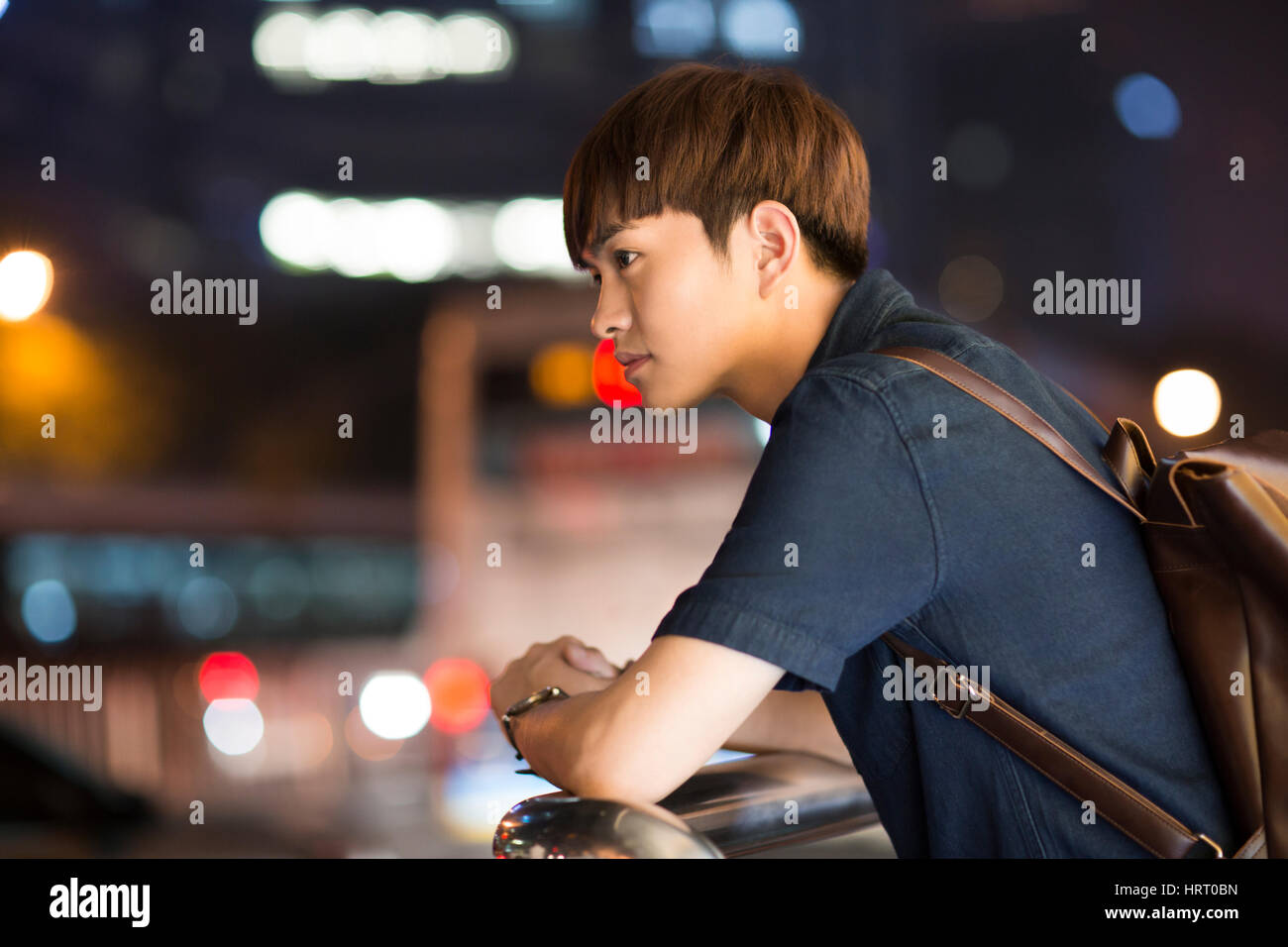 Young man waiting at the bus stop Stock Photo - Alamy