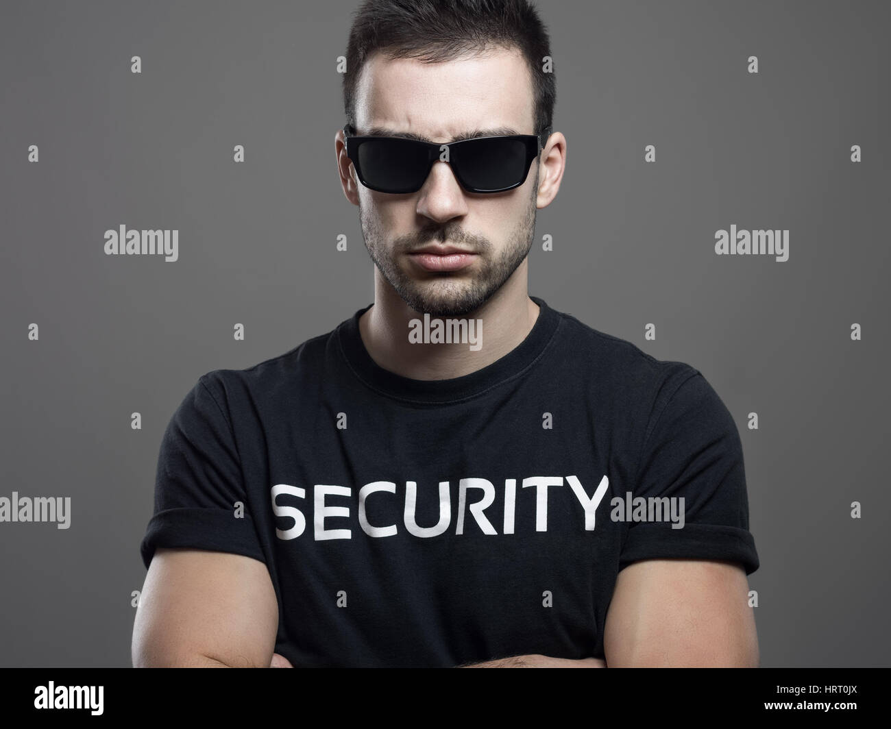 Dramatic portrait of tough macho security guard man with crossed arms ...