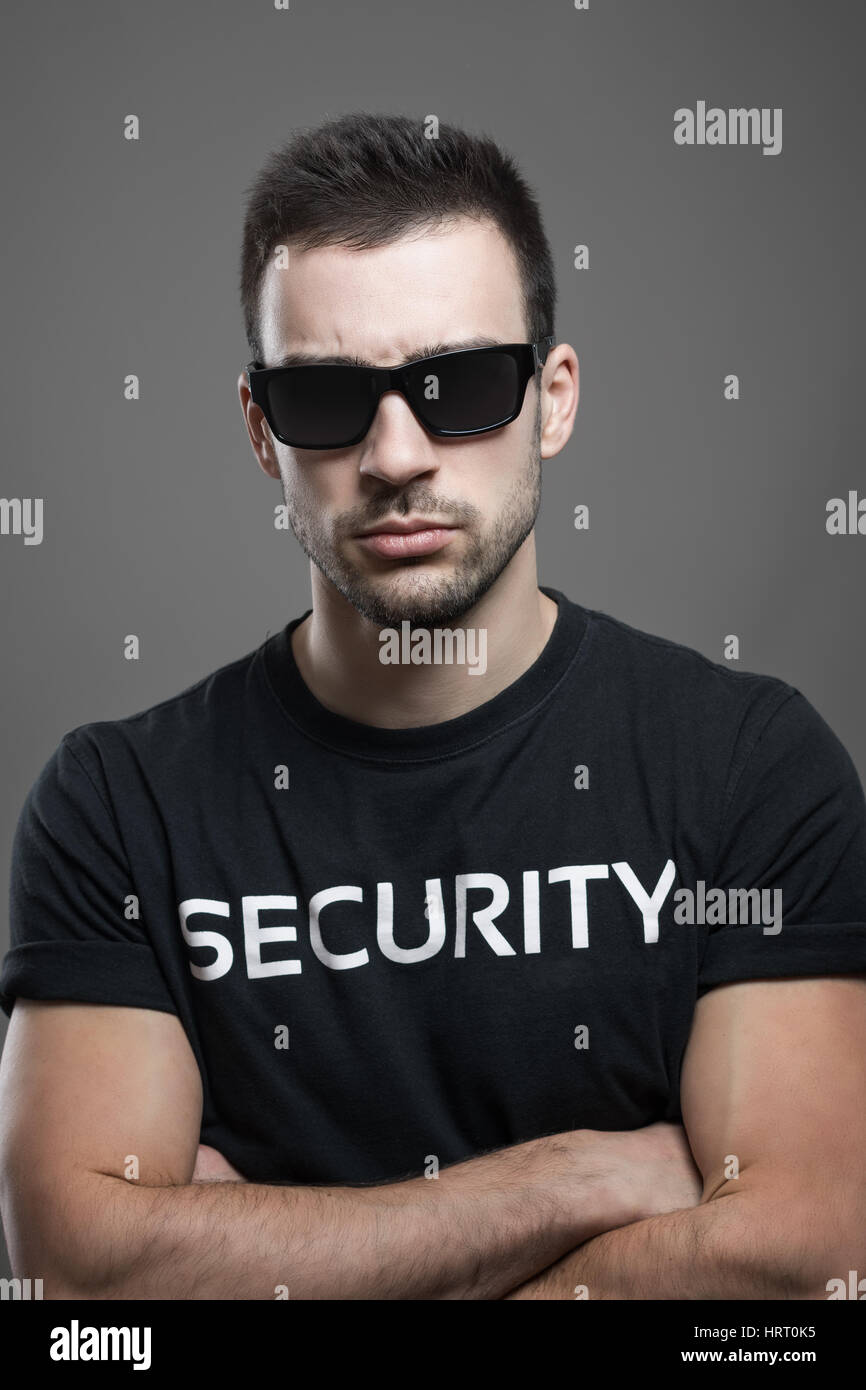 Tough macho serious male security guard with sunglasses and crossed ...