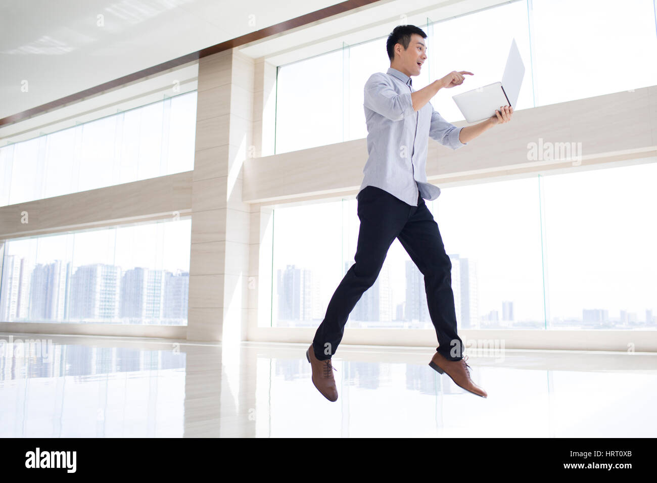 Man jumping using laptop hi-res stock photography and images - Alamy