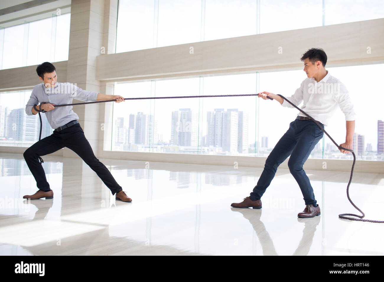 Young businessmen pulling rope Stock Photo - Alamy