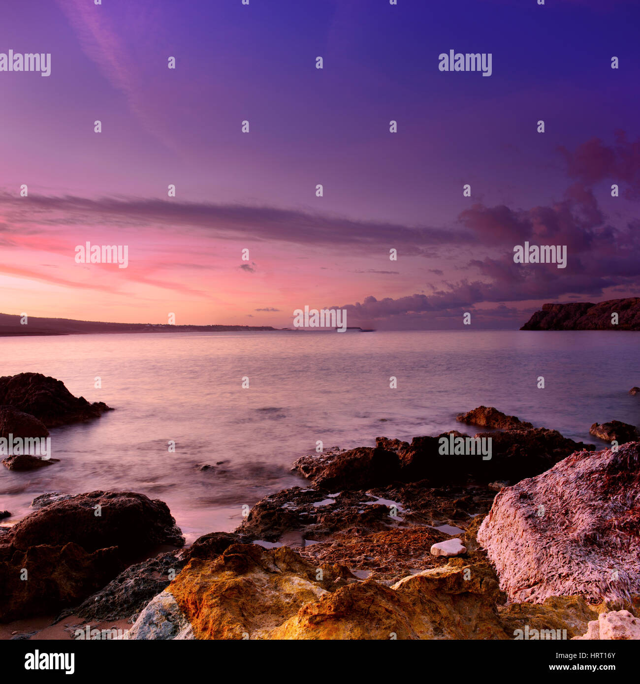 Beautiful colorful sunrise at the sea with dramatic clouds and boulders ...