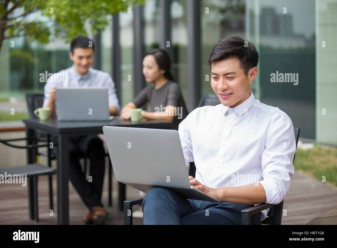 Young businessman using laptop outdoors Stock Photo - Alamy