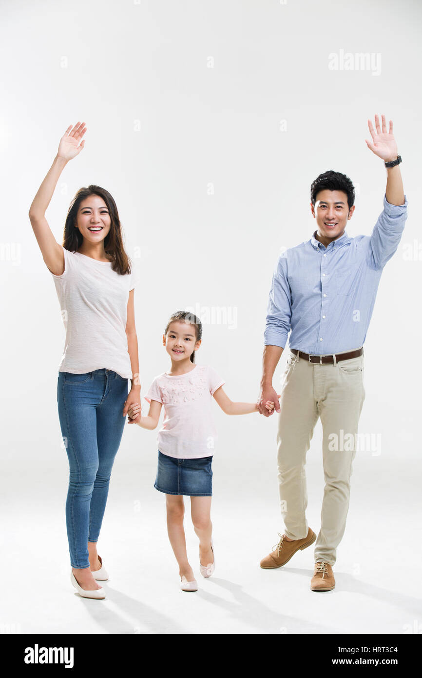 Cheerful young family waving Stock Photo - Alamy