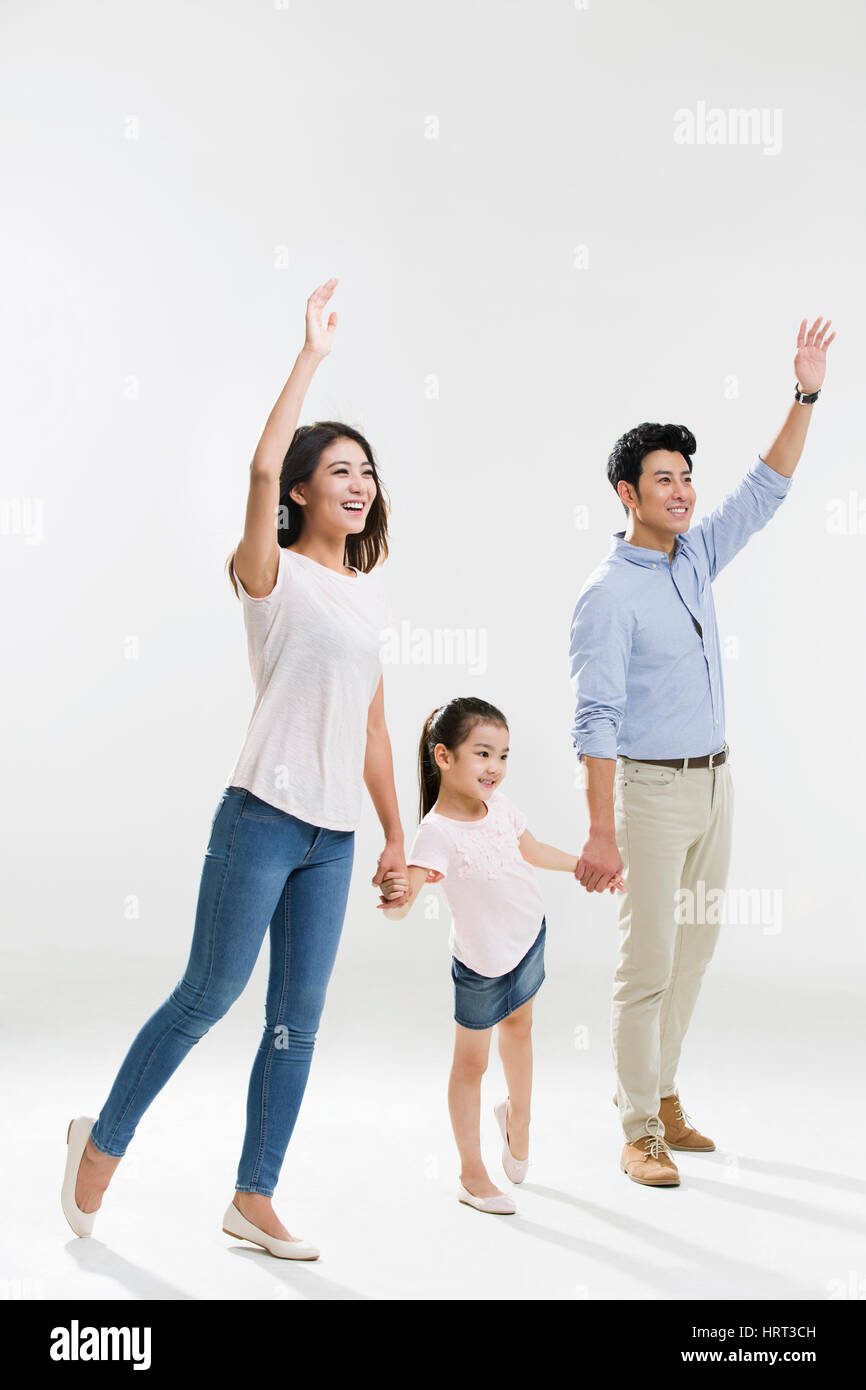 Cheerful young family waving Stock Photo - Alamy