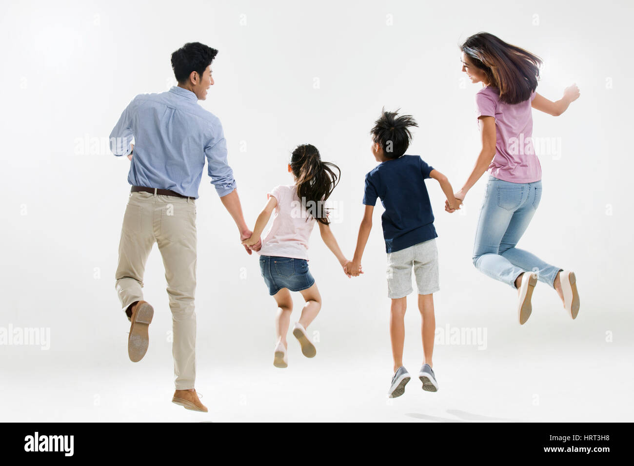 Cheerful young family jumping Stock Photo - Alamy