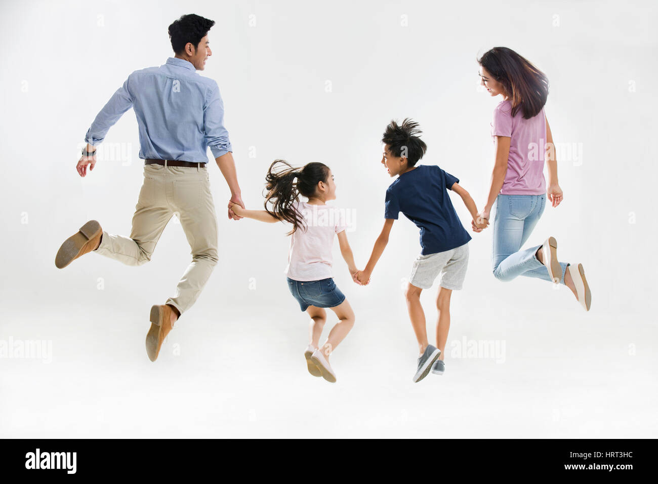 Cheerful young family jumping Stock Photo - Alamy